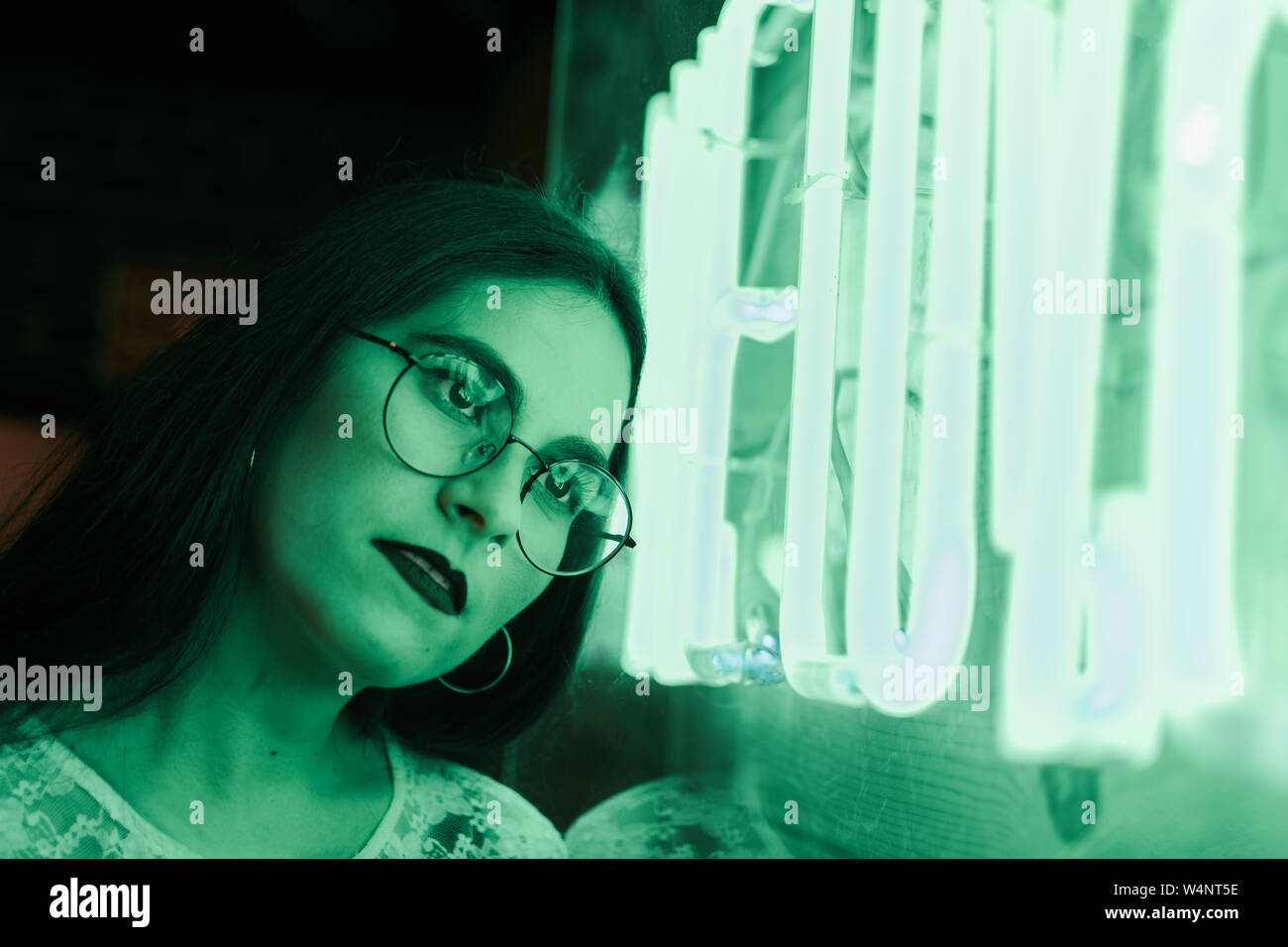 Young woman with glasses with reflections of a neon sign Stock Photo ...