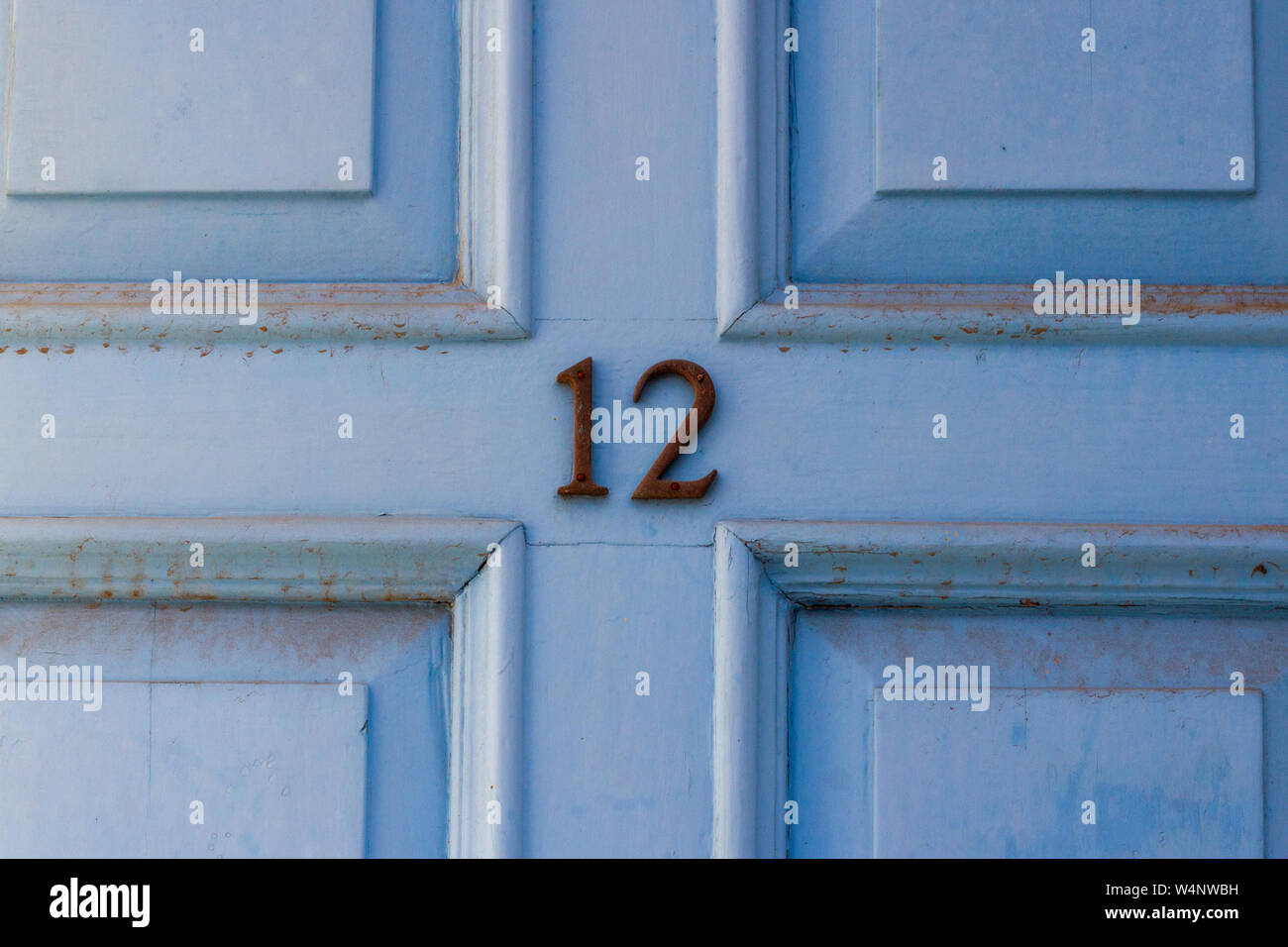 House number 12 on a light blue wooden front door with cross panel ...