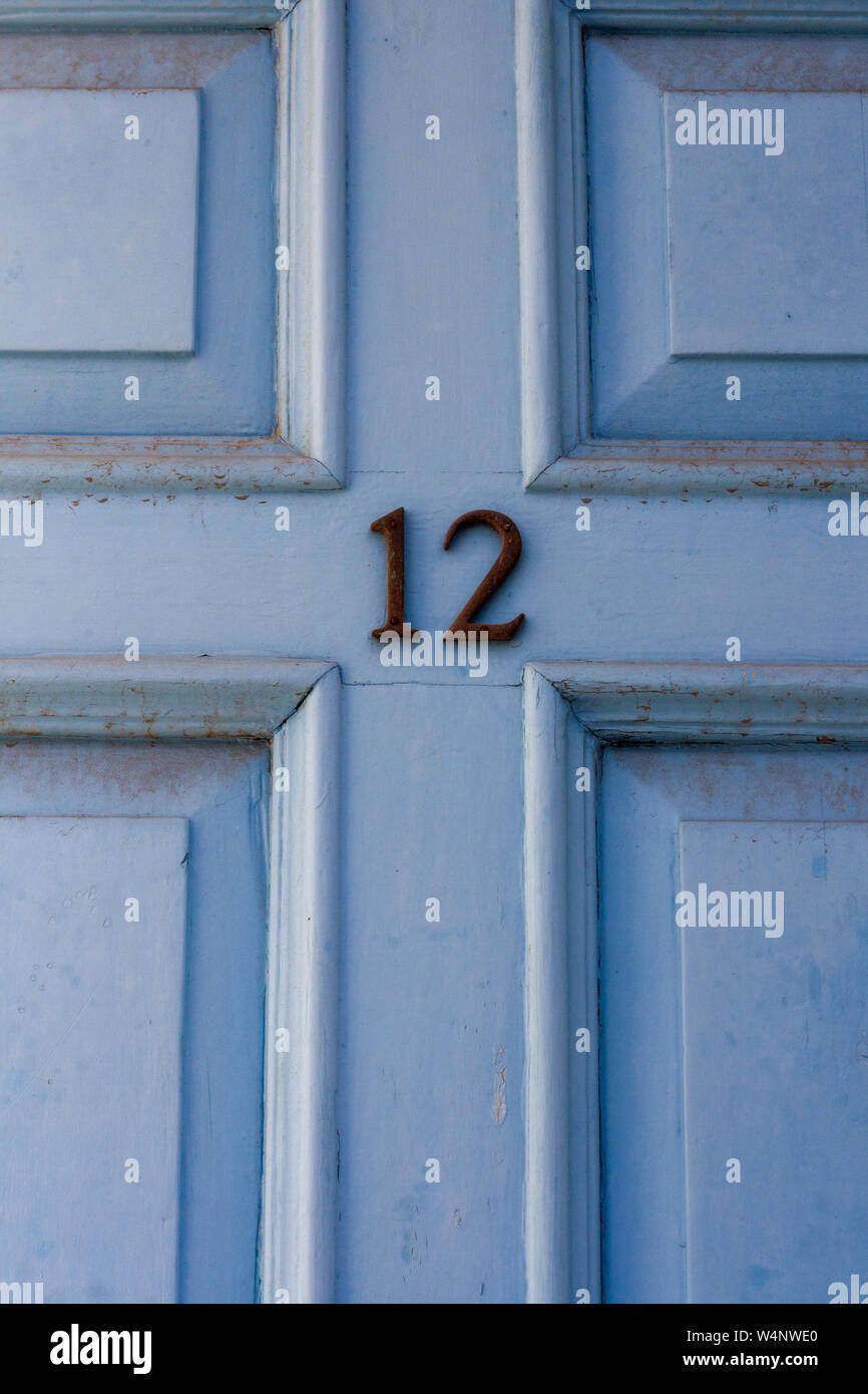 House number 12 on a light blue wooden front door with cross panel ...
