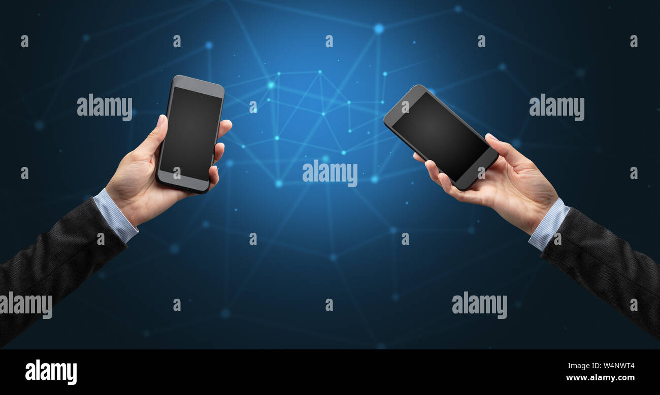 Close up of two hands holding smartphones to each other, wireless ...