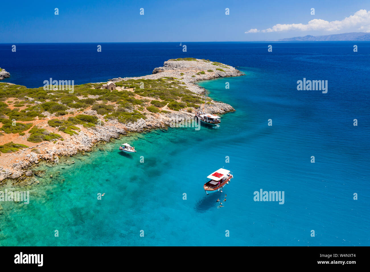 Aerial view of swimmiers and snorkellers in a hot, crystal clear ocean ...