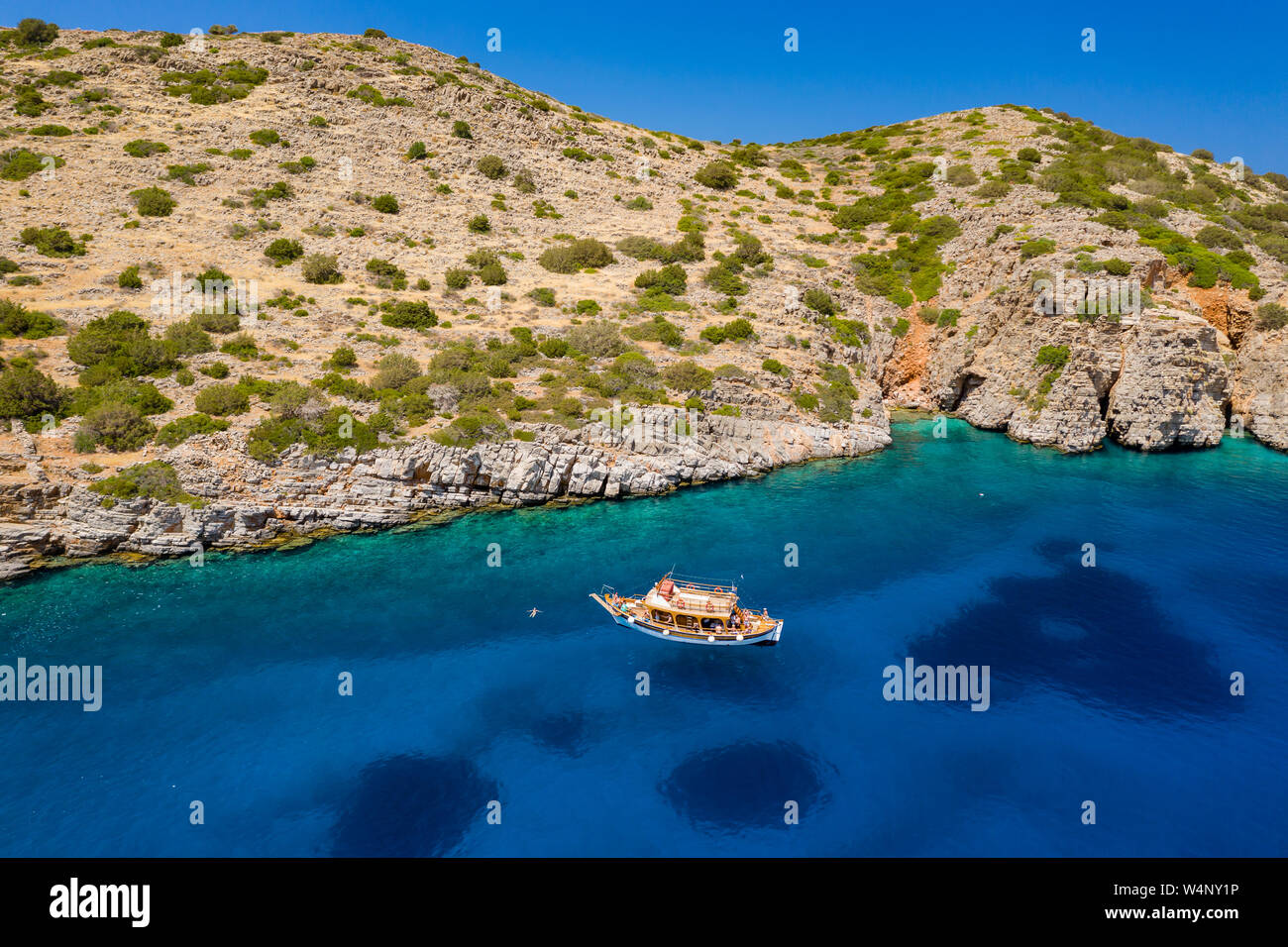 Aerial view of swimmiers and snorkellers in a hot, crystal clear ocean ...
