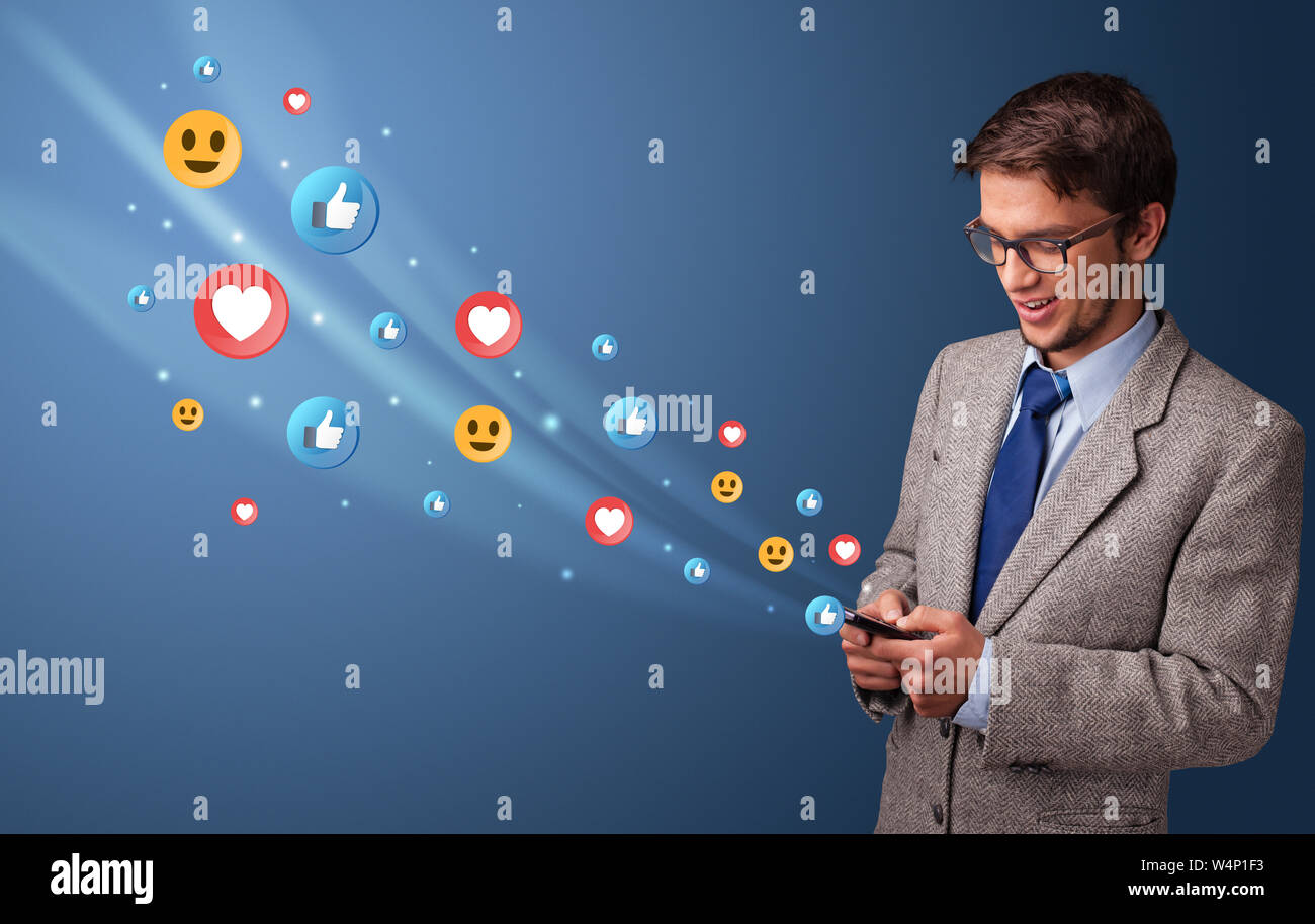 Young person using smartphone with flying social media icons around ...