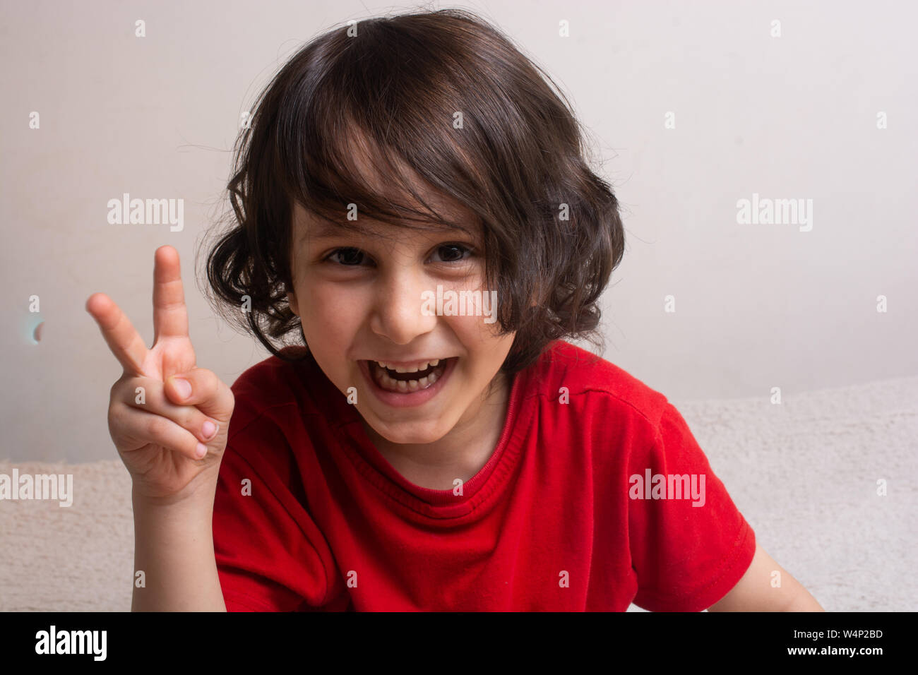 Smiling kid with happy face making and victory peace gesture Stock ...