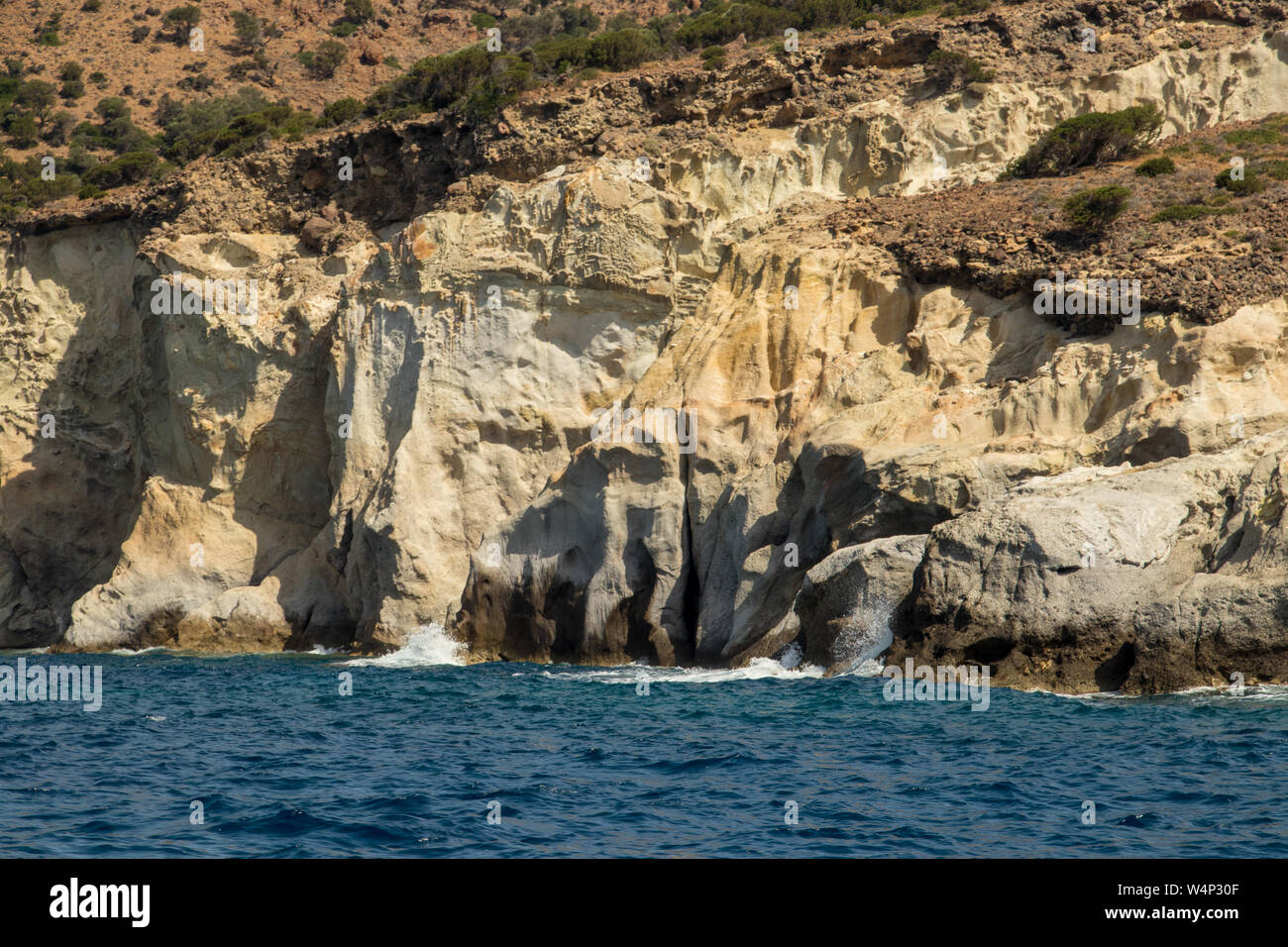 yellow color shoreline of Milos island Stock Photo - Alamy