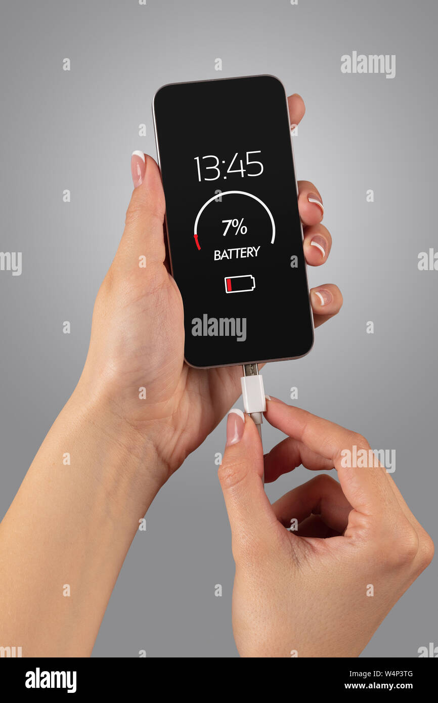 Elegant hand charging cellphone with low battery Stock Photo - Alamy