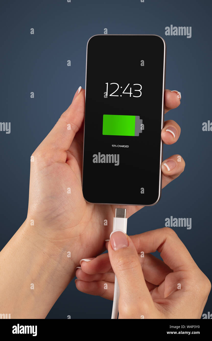 Elegant hand charging smartphone with low battery Stock Photo - Alamy