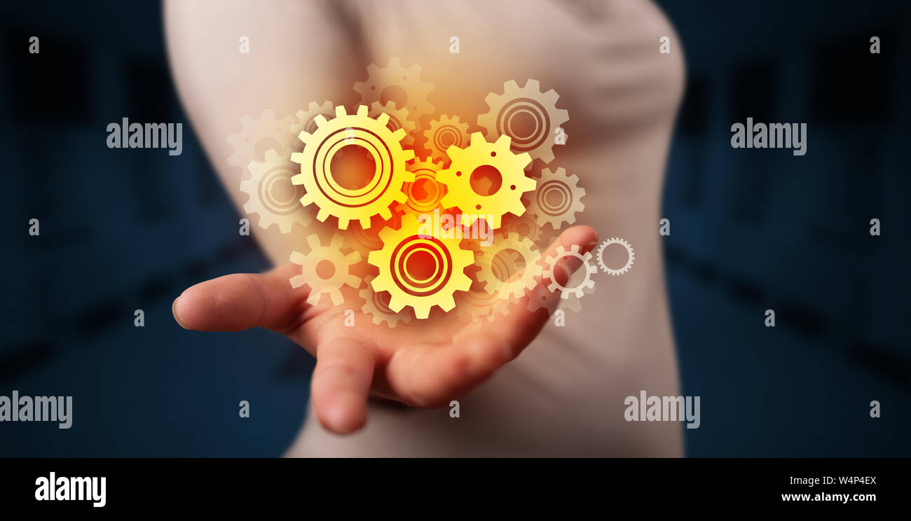 Hand holding gears in his hand Stock Photo - Alamy