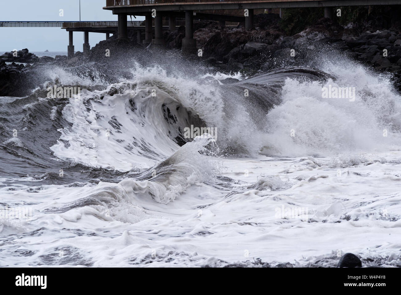 Rolling wave on stone coastline at storm. Portuguese island of Madeira ...