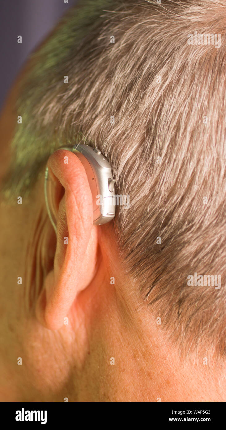Caucasian white old aged man wearing modern digital hearing aid in ear ...