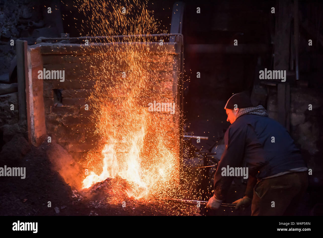 young traditional Blacksmith working with open fire The blacksmith ...
