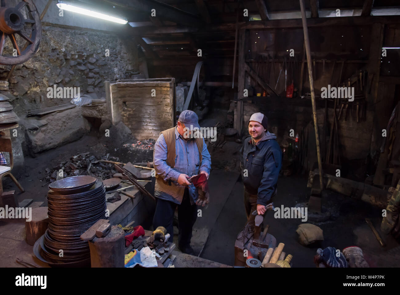 portrait of two generations traditional confident blacksmith workers at ...