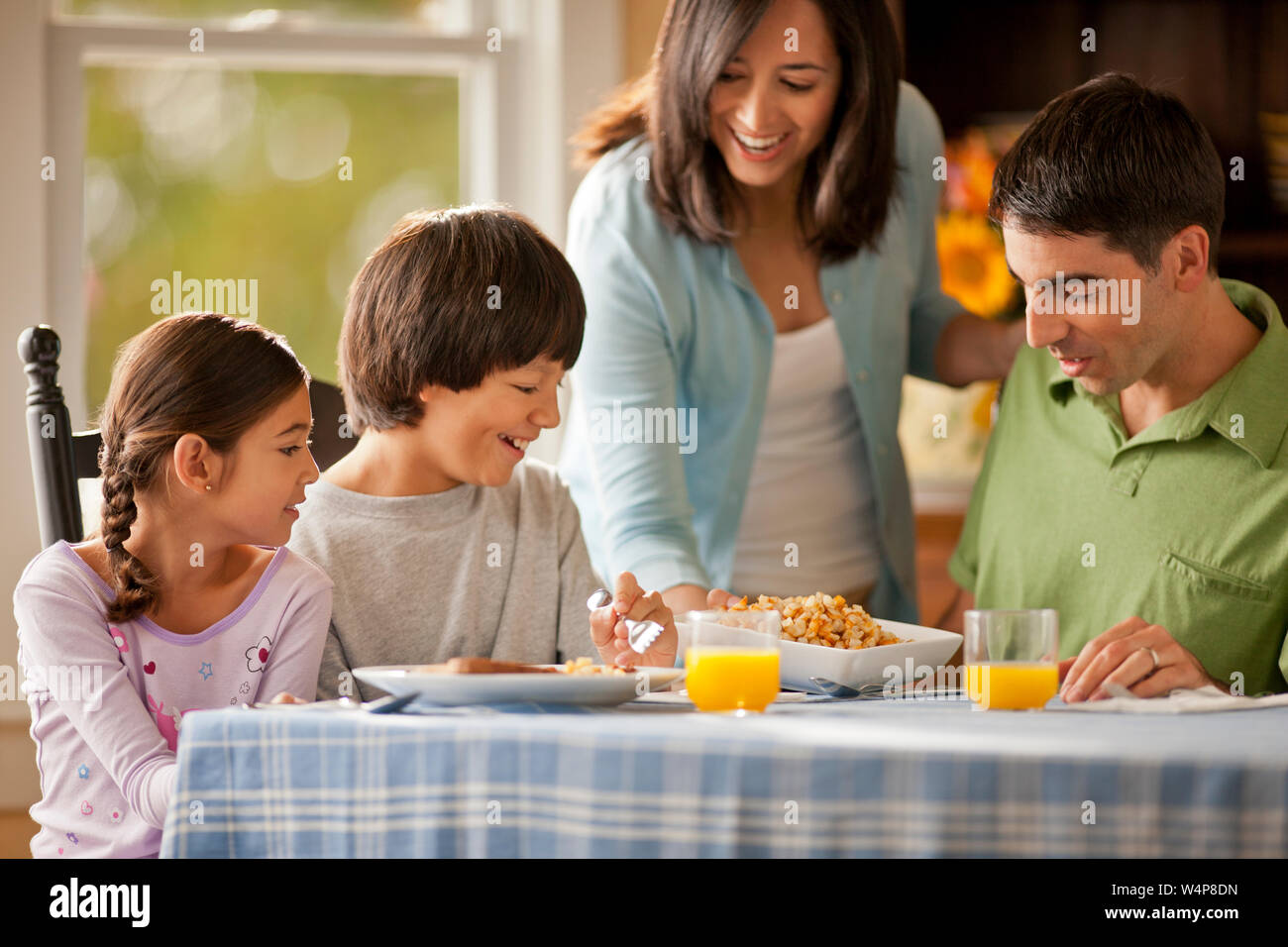 Happy family having fun eating at a dining table Stock Photo - Alamy