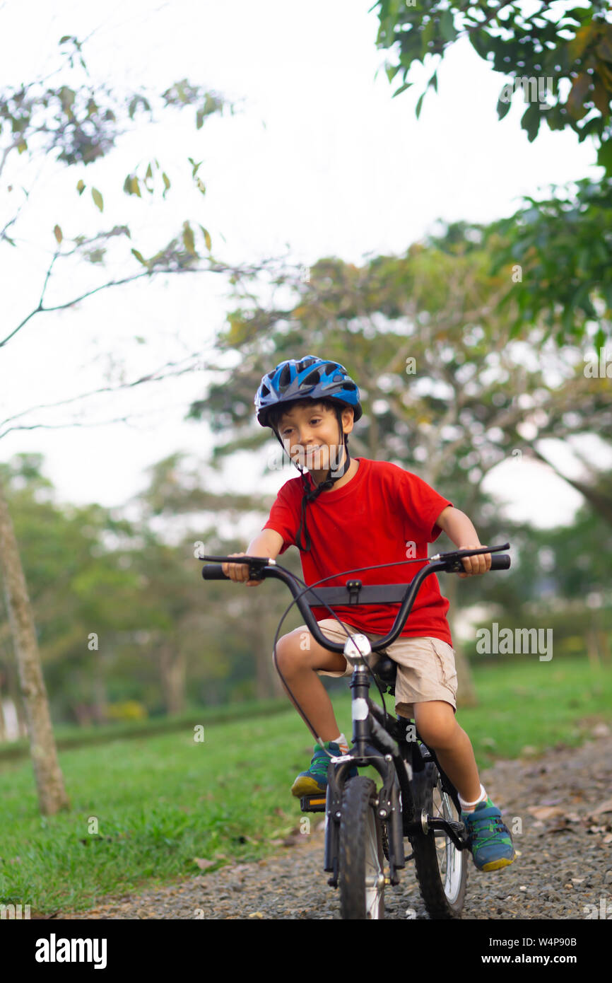 Cheerful Little Boy Riding a Bike in the Park Stock Photo - Alamy