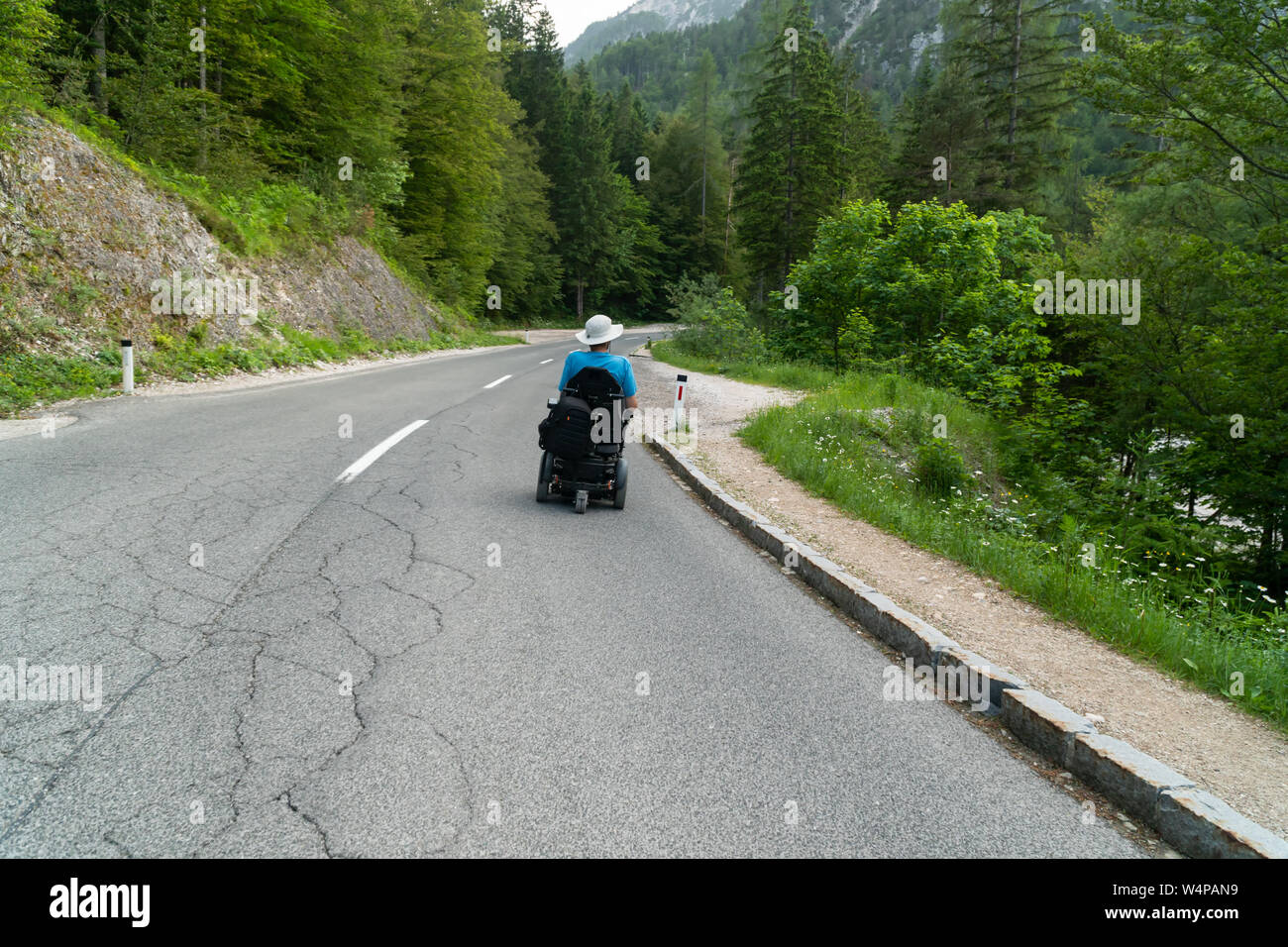 disabled person in an electric wheelchair driving on the street, road ...
