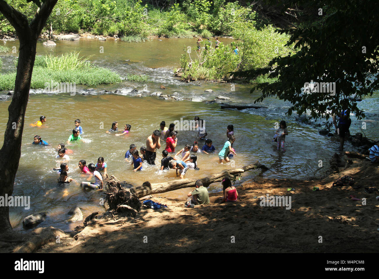 Large group of Latinos refreshing in the water in hot summer day in ...