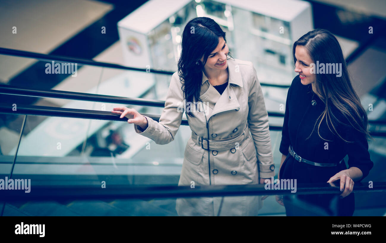 Manager and client standing on the stairs in the lobby of the office ...