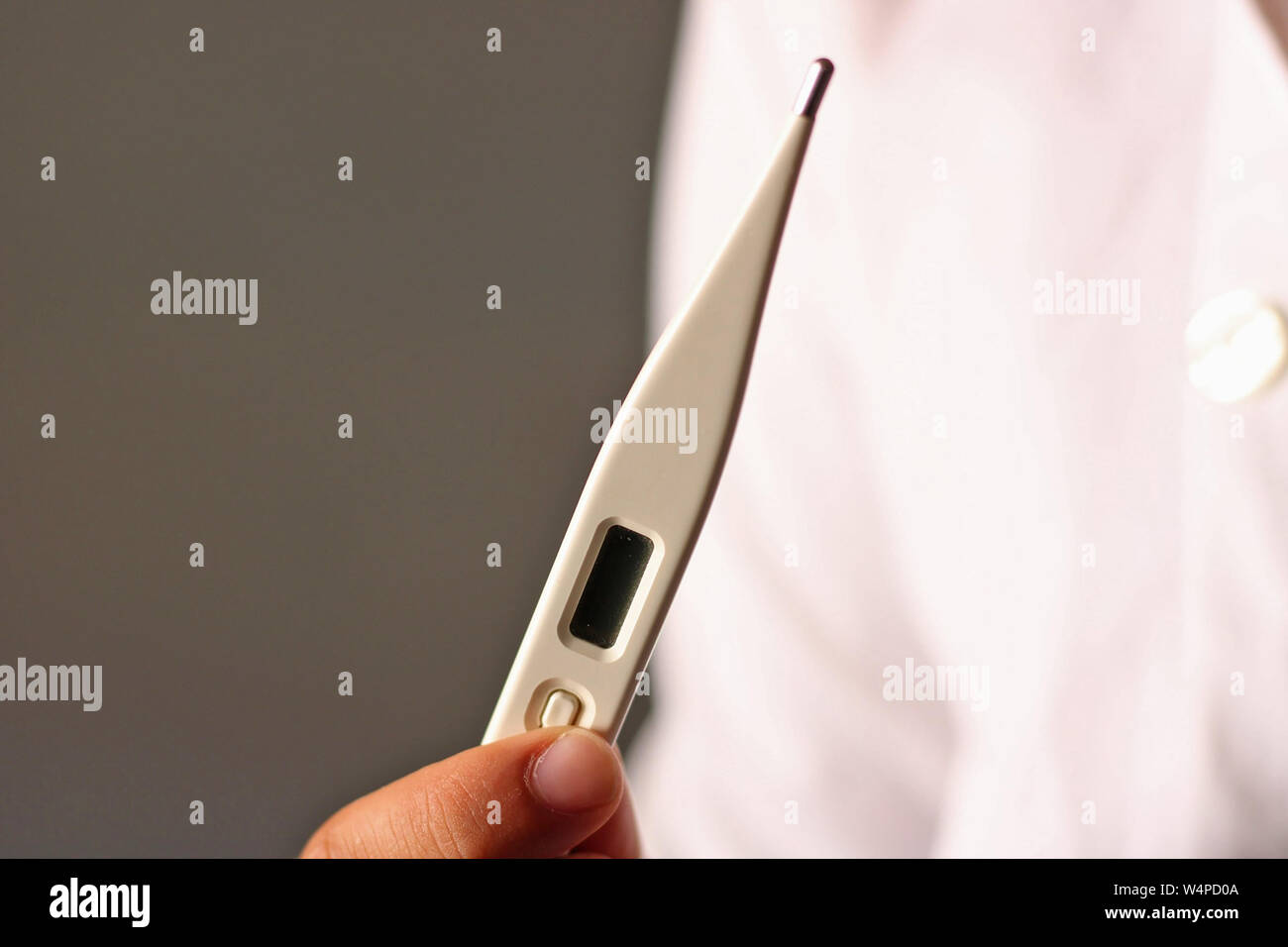 Doctor dressed in white holding the thermometer Stock Photo - Alamy