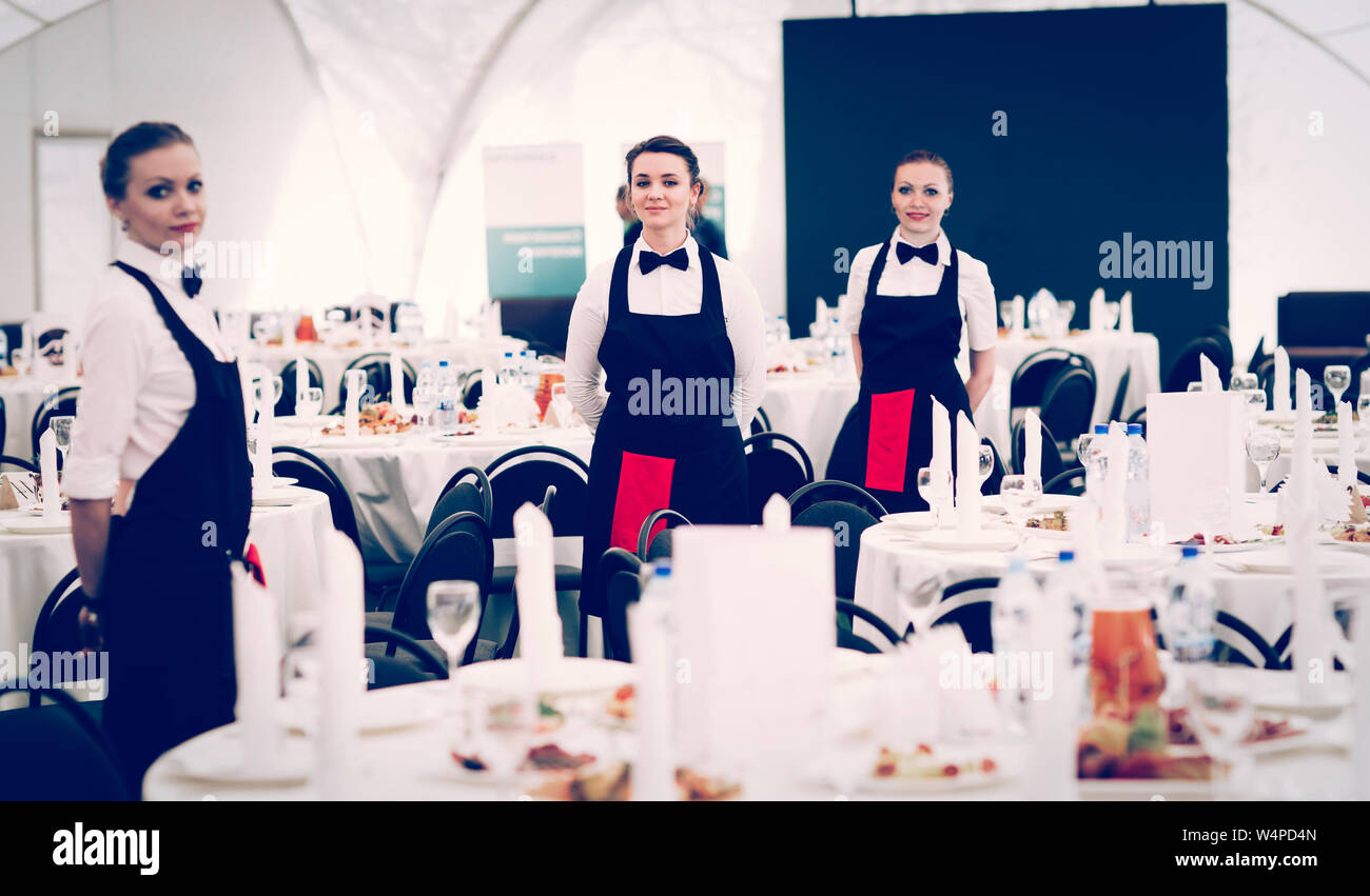group of waiters at a prestigious restaurant served tables to the ...