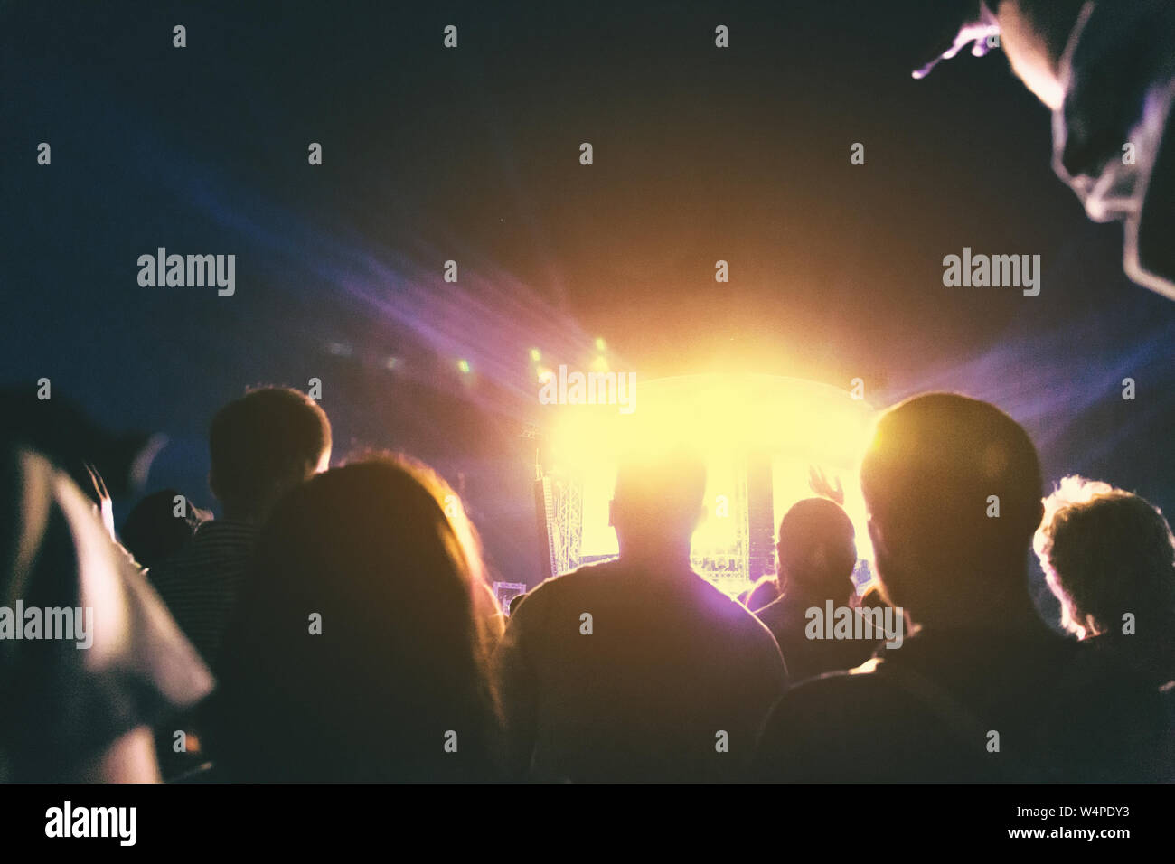Crowd of spectators having fun at a concert applauding musicians on ...