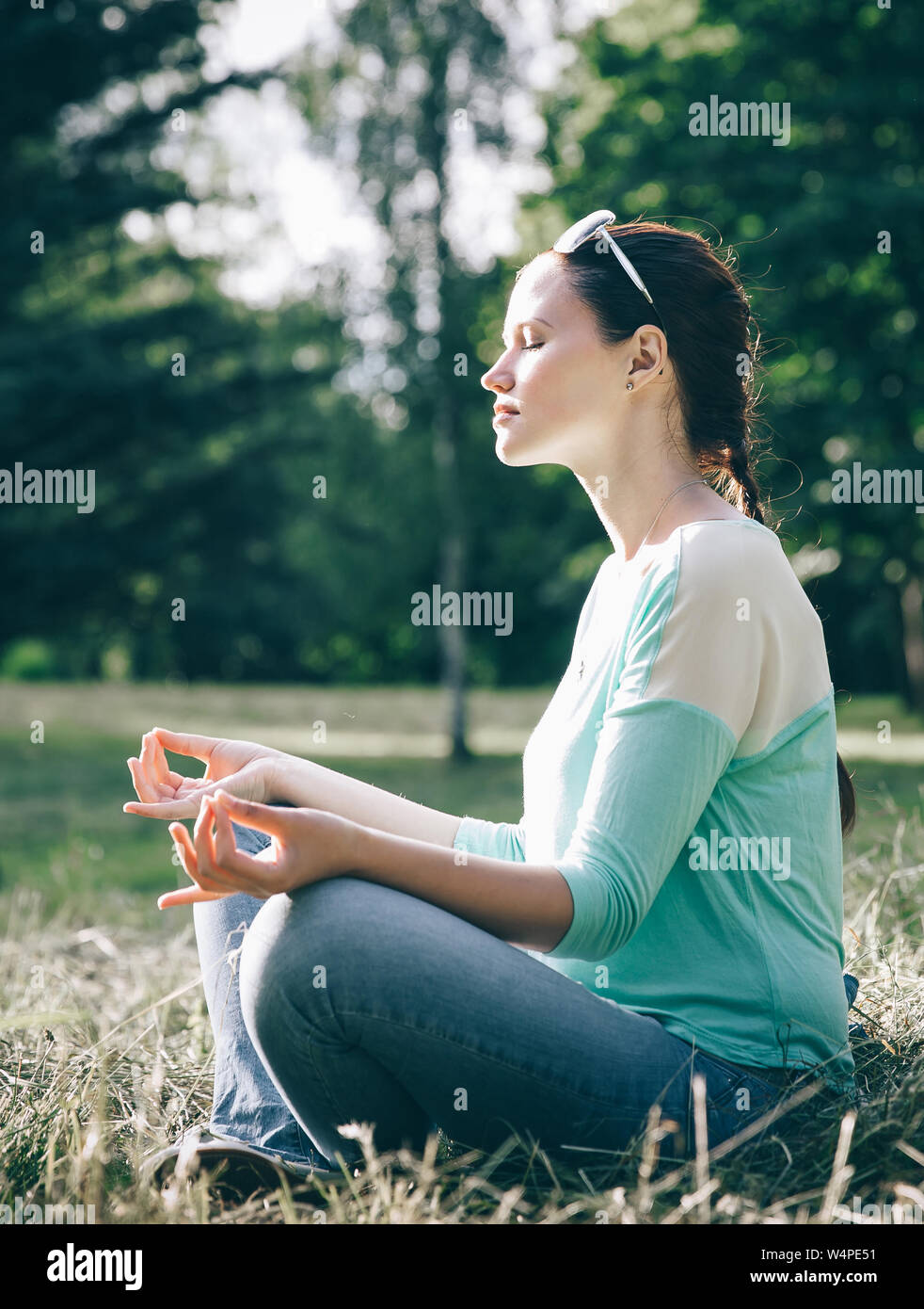 side view.beautiful woman meditating in Lotus position outdoors. the ...