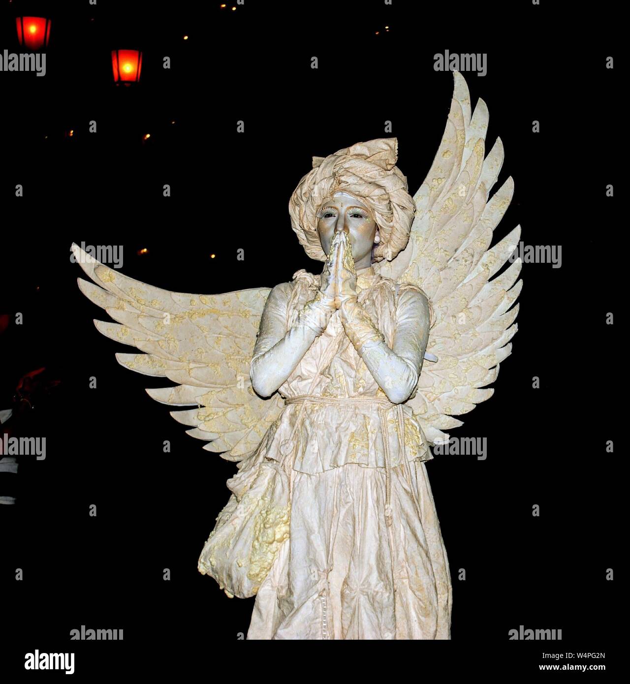 Female street artist performing as angel living statue Stock Photo - Alamy