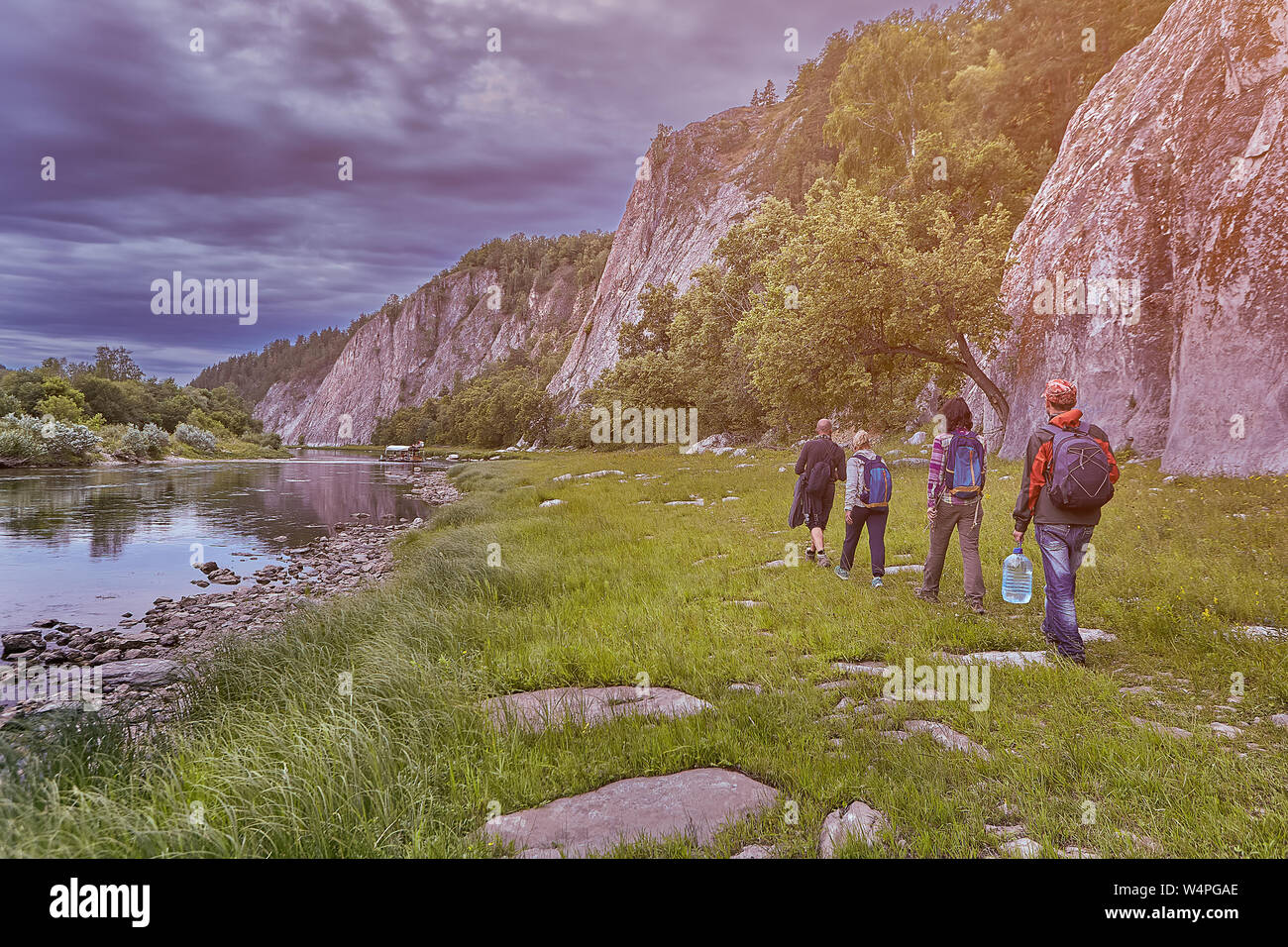 Eco-tourism, the group hikers walking on the path along the river, in a ...