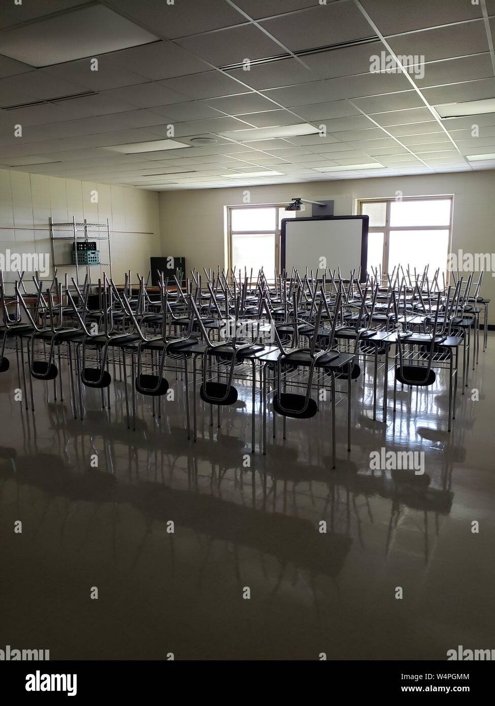 Chairs up on desks in a classroom that has been summer cleaned and is ...