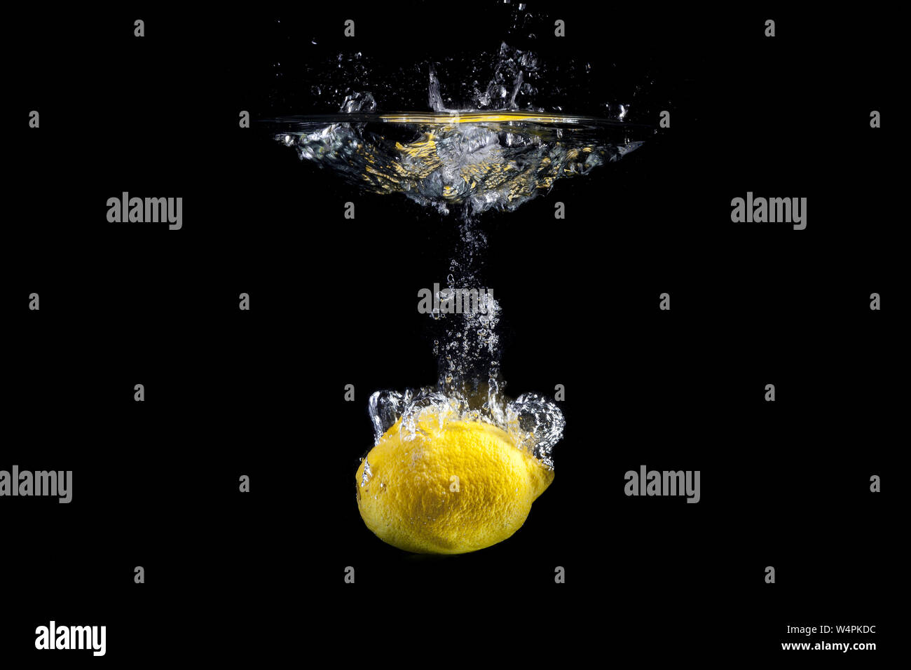 Fresh fruit dropped into water with splash on black background Stock ...