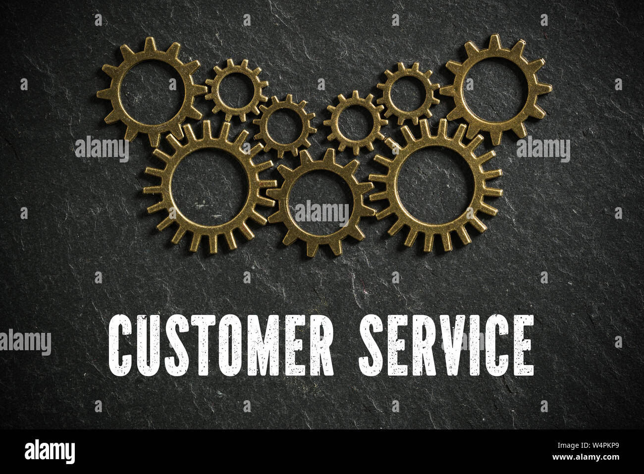 cogwheels and the words "customer service" on slate background ...