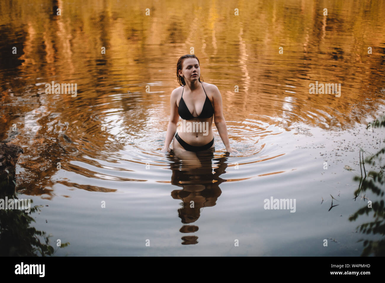 Seductive woman in a bikini walking in lake Stock Photo - Alamy