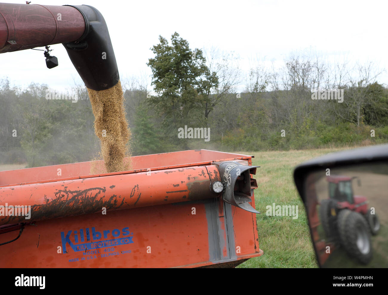 A farmer rides in a combine as he harvests a crop of soybeans on his ...