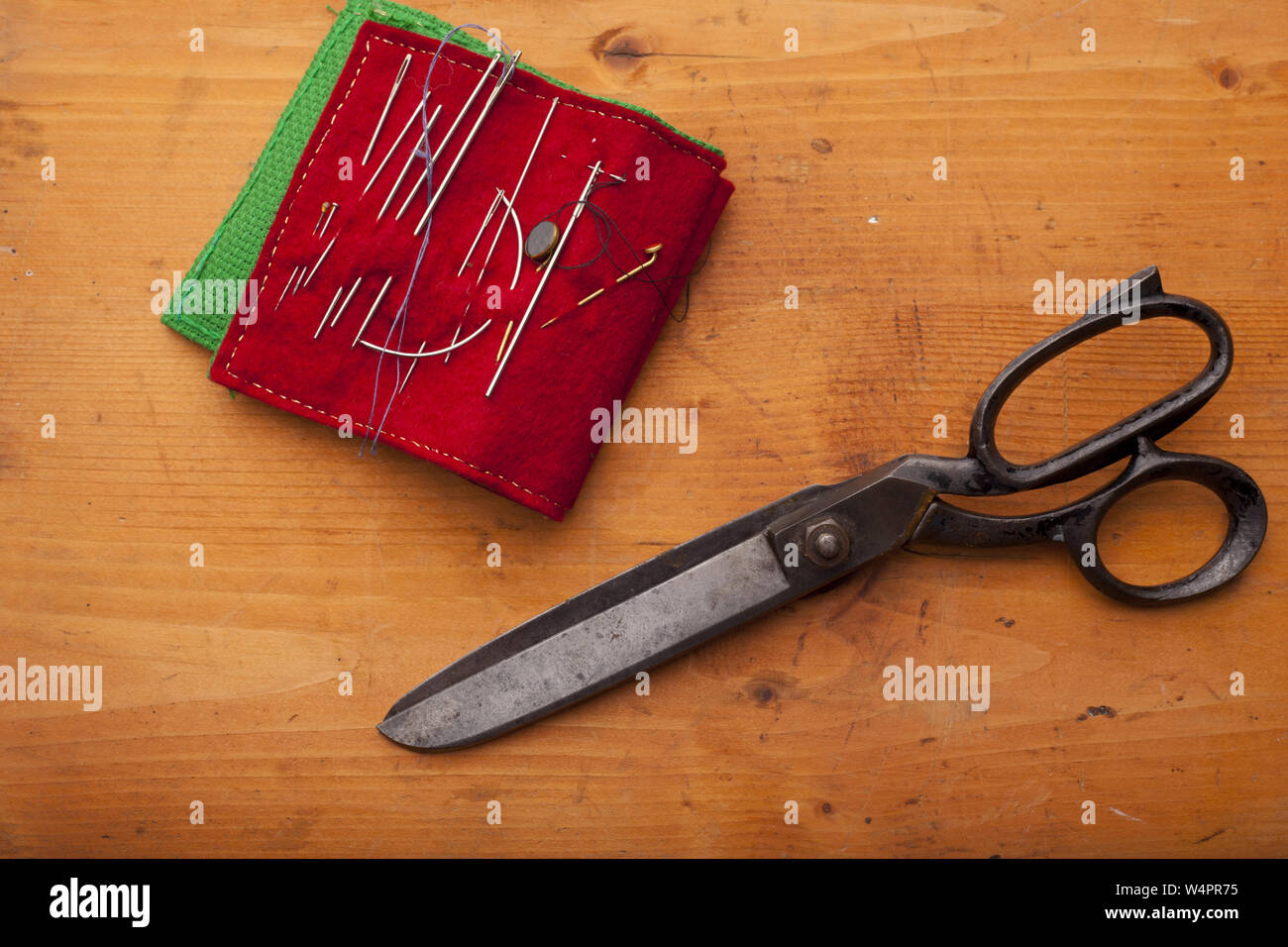 dressmaker shears with needle case craft concept on wooden texture ...