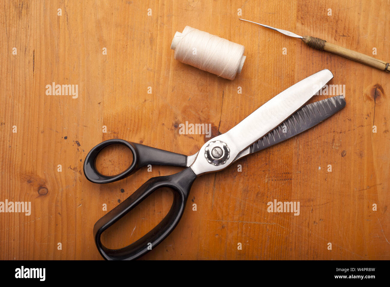 Pinking shears with spool and Crochet tool craft concept on wooden ...