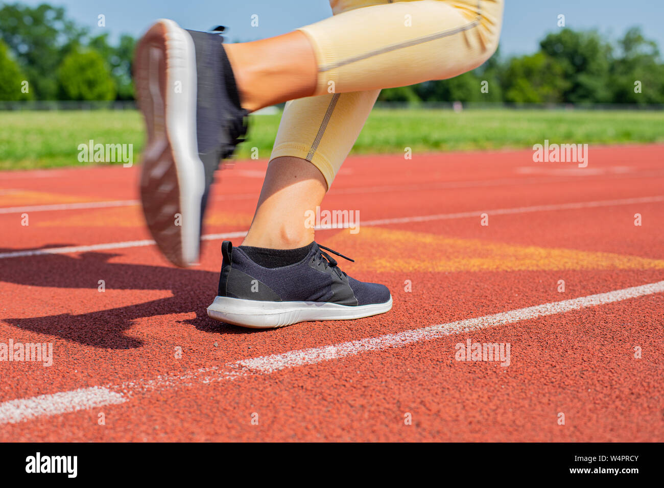 Close-up feet of woman running on track, runner on running lane Stock ...