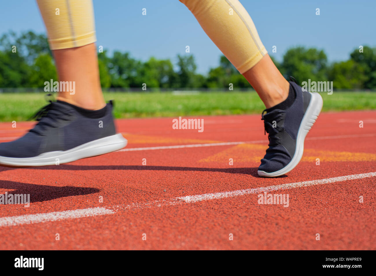 Close-up feet of woman running on track, runner on running lane Stock ...