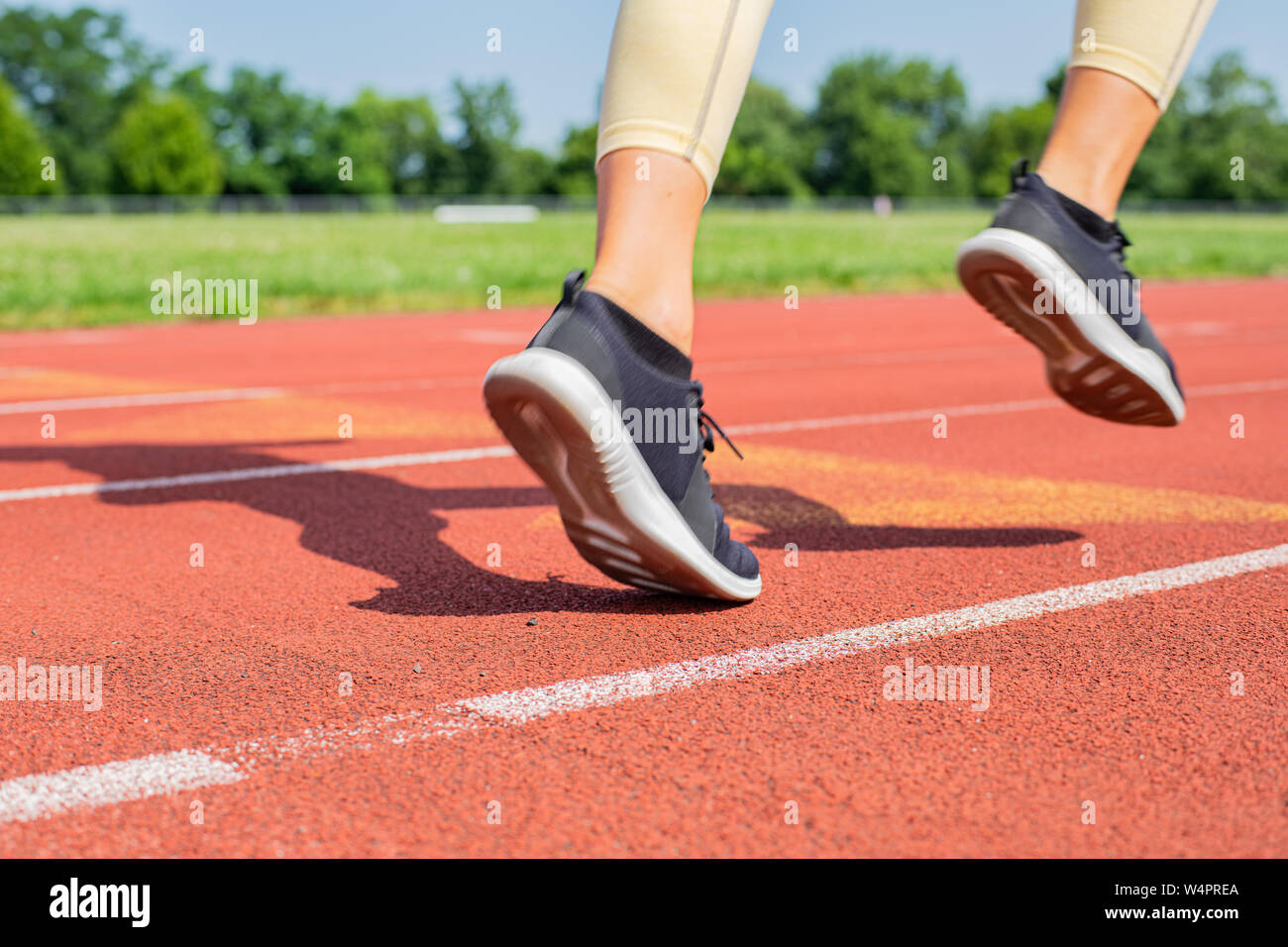 Close-up feet of woman running on track, runner on running lane Stock ...