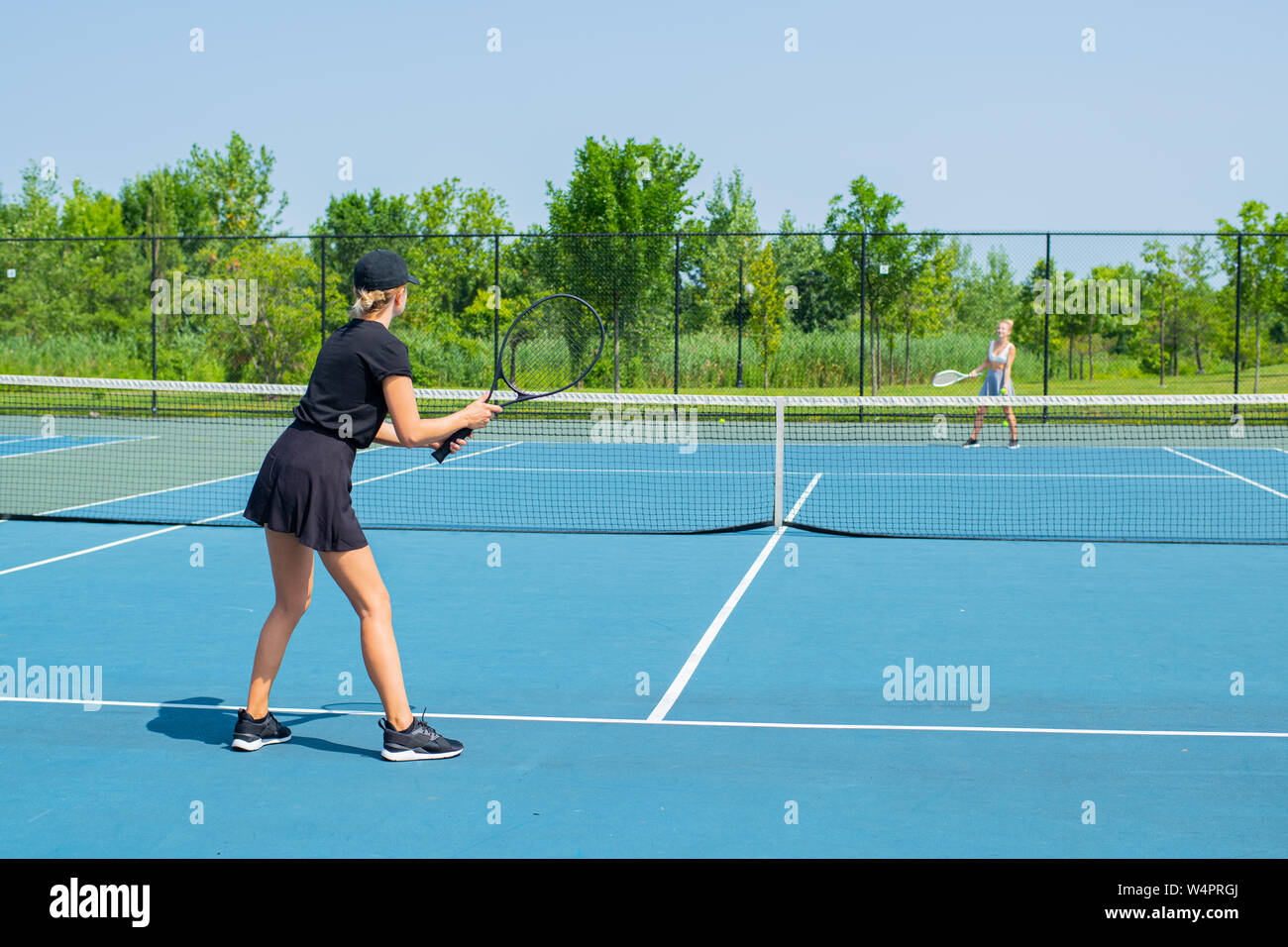 Two young sports women playing tennis on the blue tennis court Stock ...