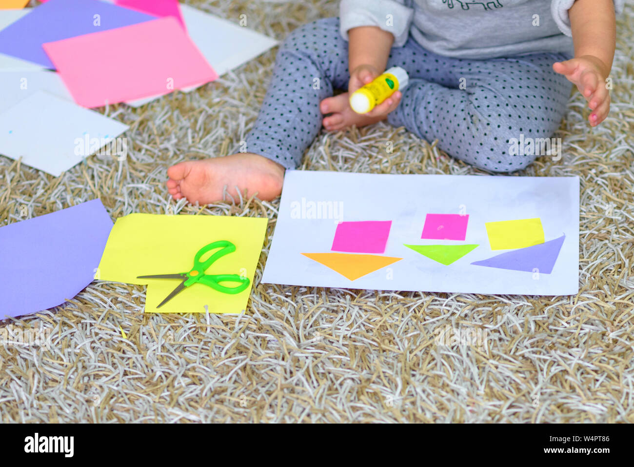 Cute little girl make applique, glues colorful house, applying a color ...