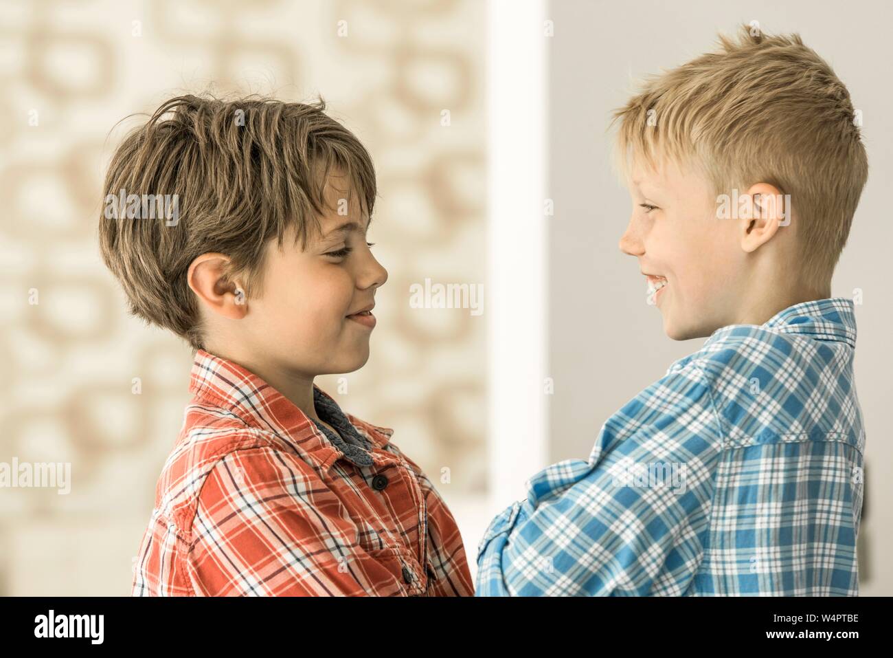Two boys in plaid shirts, friends, 10 years old, looking at each other ...