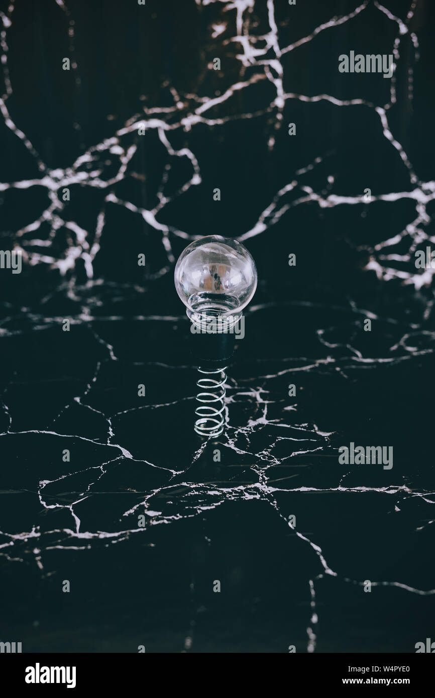 idea lightbulb popping up on spring with black marble background ...