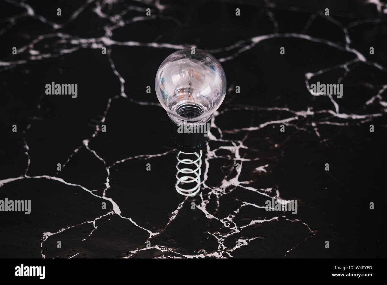 idea lightbulb popping up on spring with black marble background ...