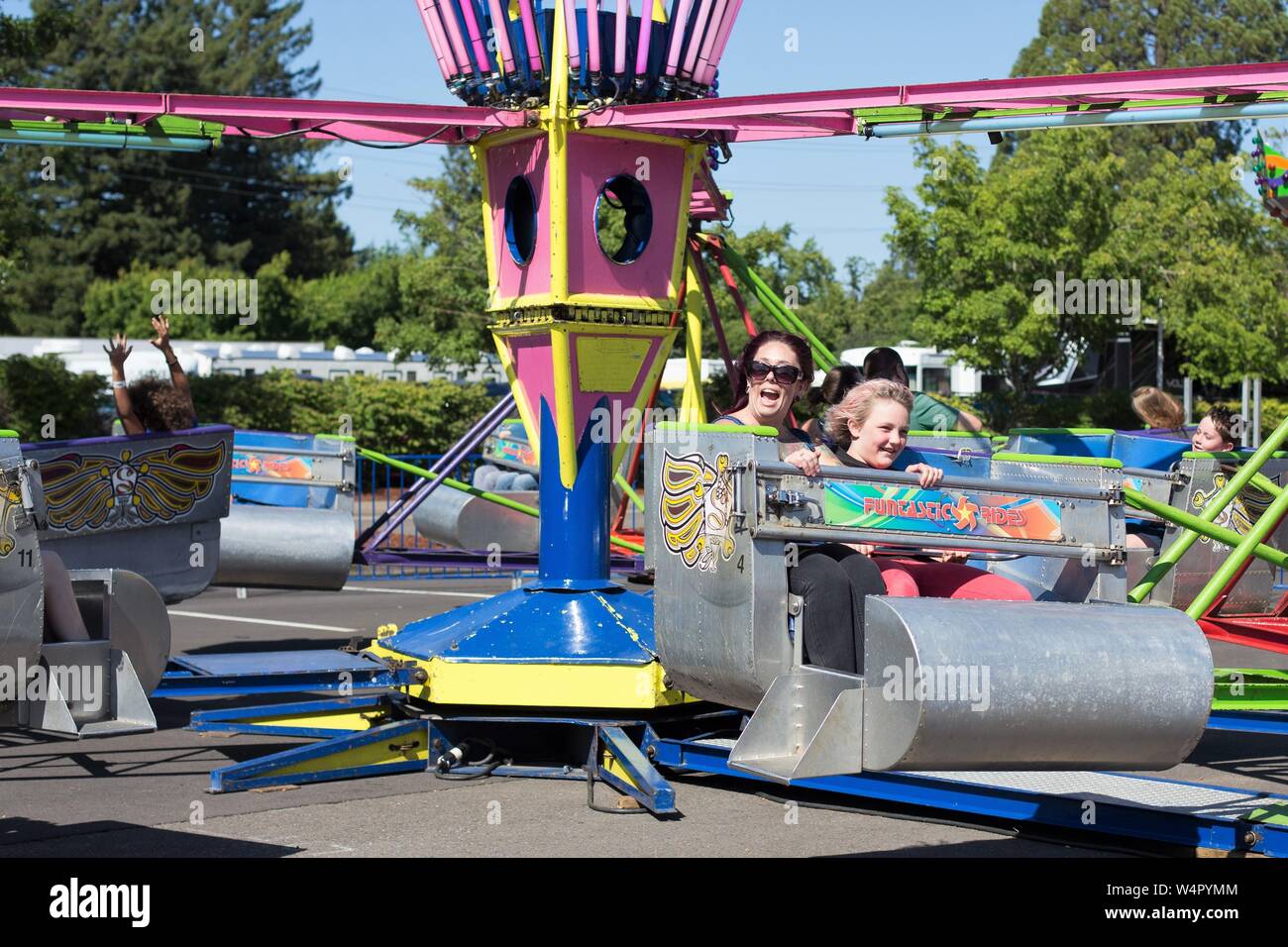 People riding an amusement park ride at a county fair in Oregon, USA ...