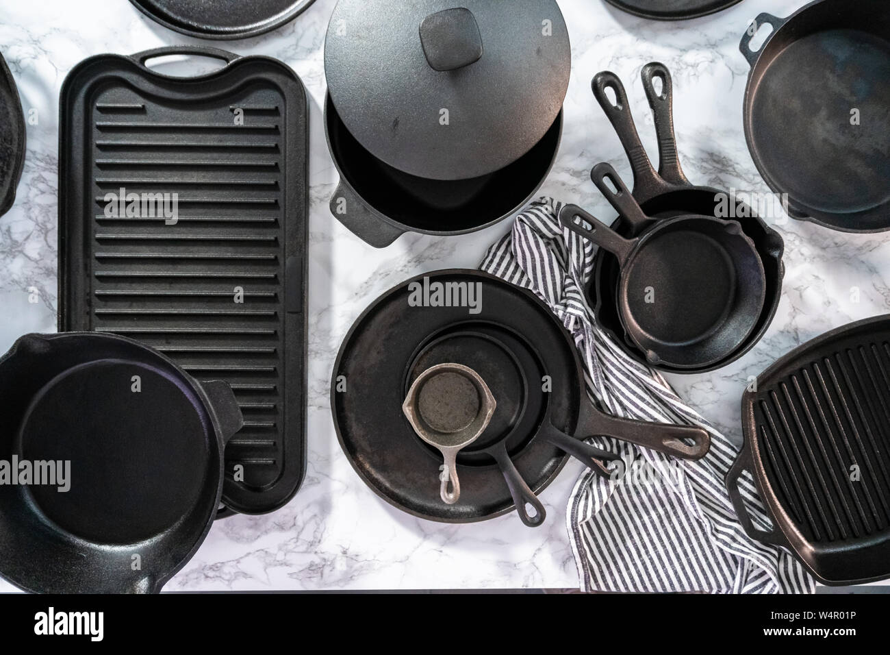 Flat lay. Variety of cast iron frying pans on a marble background Stock ...