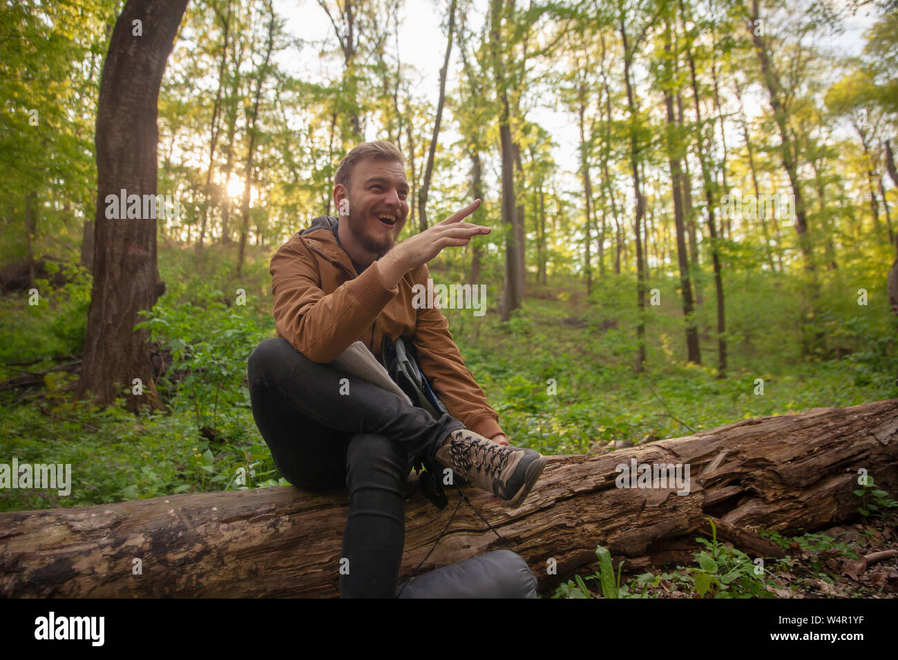 one young man, laughing in forest alone, pointing finger Stock Photo ...