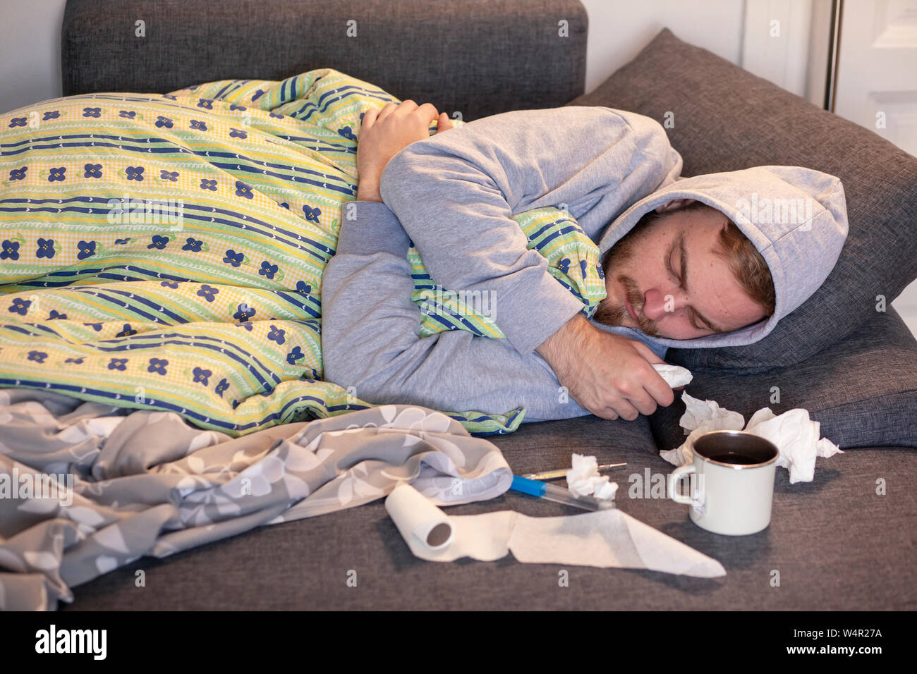 One young man, sleeping in bed, feeling sick Stock Photo - Alamy
