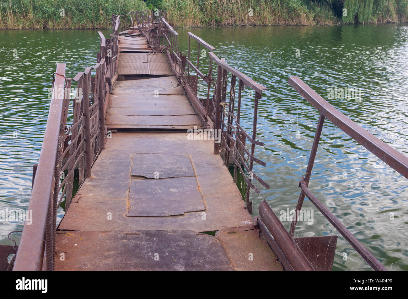 Old, rusty pontoon-bridge over small river Sura to remote Ukrainian ...