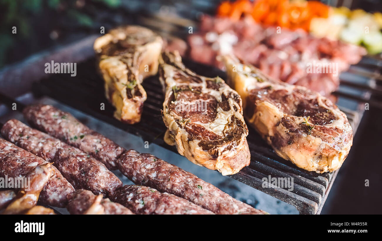 Large pieces of pickled meat on a grid in a restaurant. Mixed grilled ...
