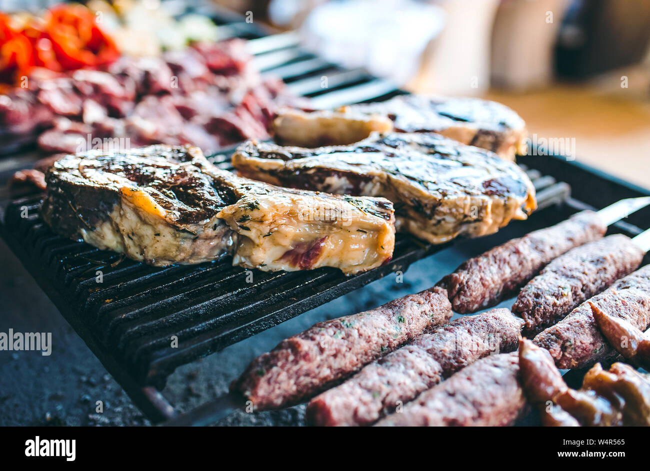 Large pieces of pickled meat on a grid in a restaurant. Mixed grilled ...