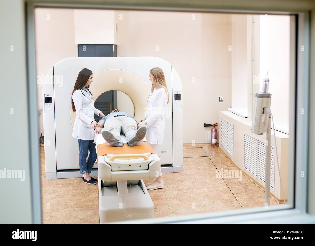 MRI machine and screens with doctor and nurse Stock Photo - Alamy